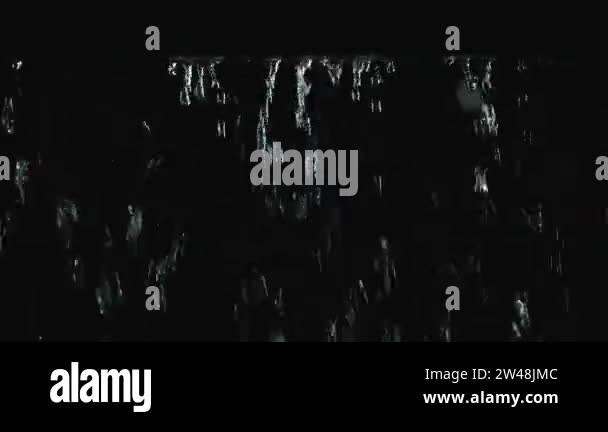 Raindrops dripping from the edge of a canopy in a dark studio. The ...