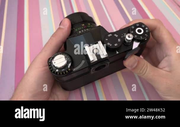 Close-up of male hands adjusting aperture and pressing the shutter ...