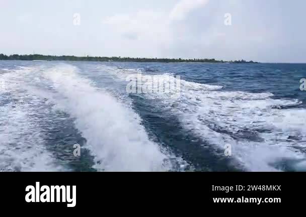 White foam water trail behind the motor boat in the Indian ocean. Fast ...