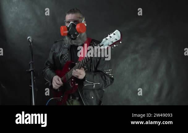 Bearded rockstar in transparent mask, respirator and leather jacket ...