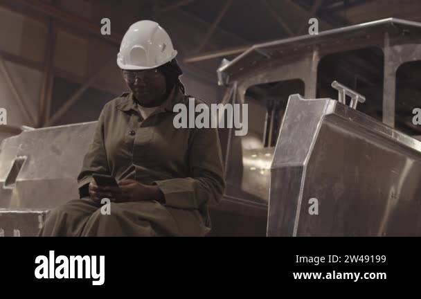 Medium long of female African construction worker wearing green ...