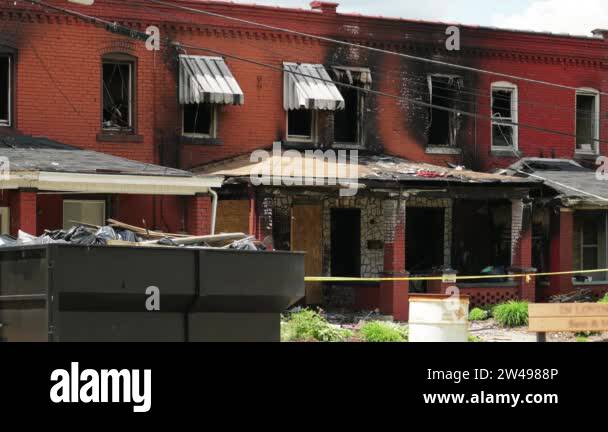 Traffic passes in front of red brick row houses that recently caught ...