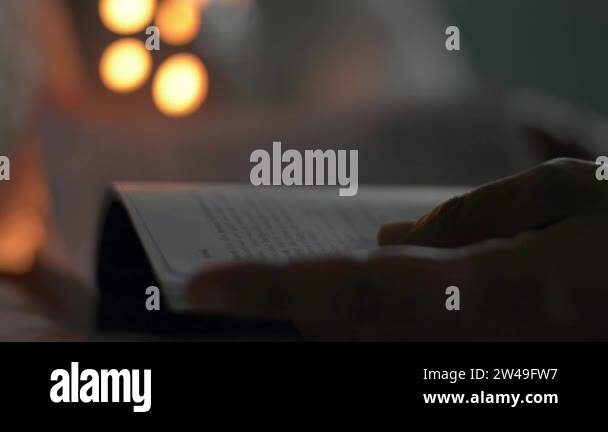 Woman's hand moves her fingers along the page while reading a book on ...