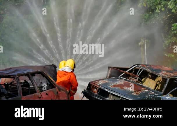 Firefighter fighting with flame using fire hose chemical water foam ...