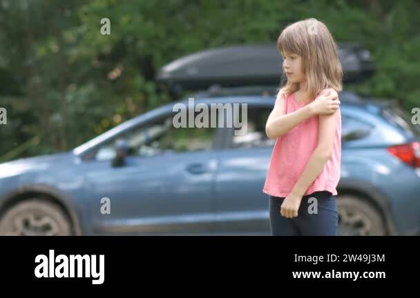 Little child girl scratching her arms from mosquito bites at campground ...