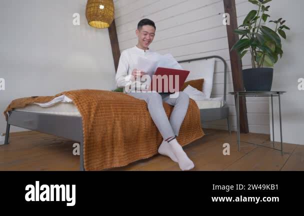 Excited Asian young man throwing up graphs making victory gesture ...