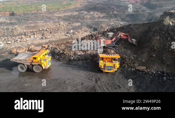 Large quarry dump truck. Loading rock in dumper. Loading coal into truck. Mining car machinery ...
