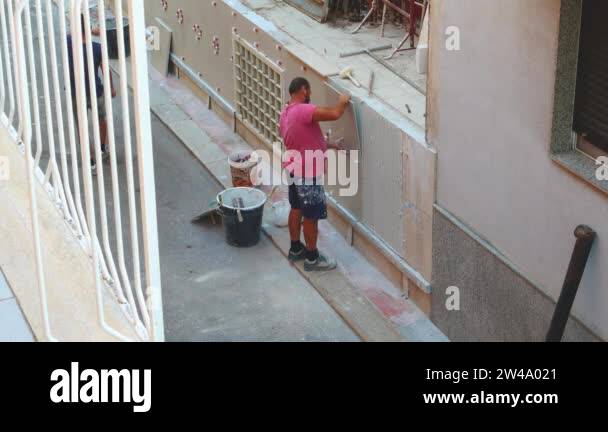 Worker labor building wall and UPVC groove line with plaster cement at ...