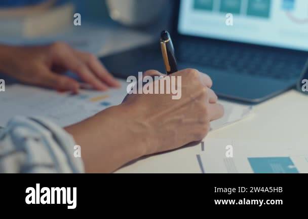 Close-up young asia lady freelance focus on laptop write worksheet ...