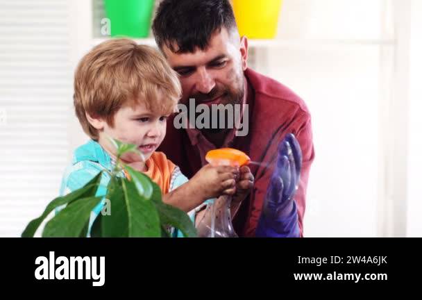 Father and son watering plants in pots. Little boy helping his father ...