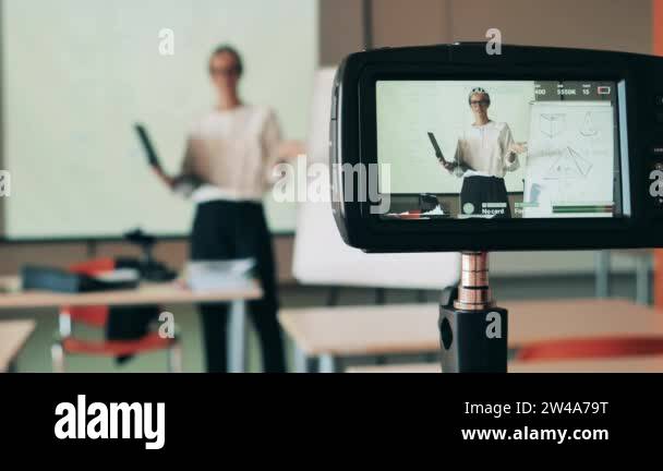 Female tutor is teaching an internet lesson and being filmed. Remote education, online education ...