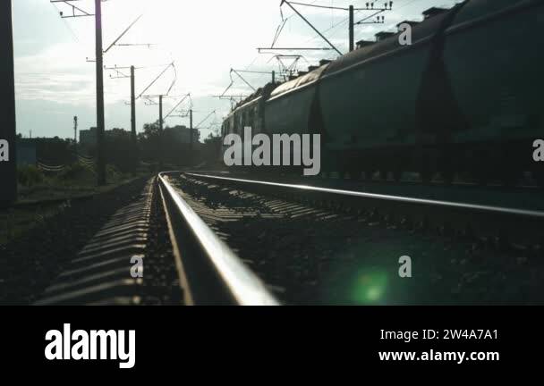 Train with wagons rides on rails at sunset. Railroad with train on ...