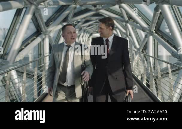 Medium front-view slowmo of two Asian and Caucasian middle-aged ...