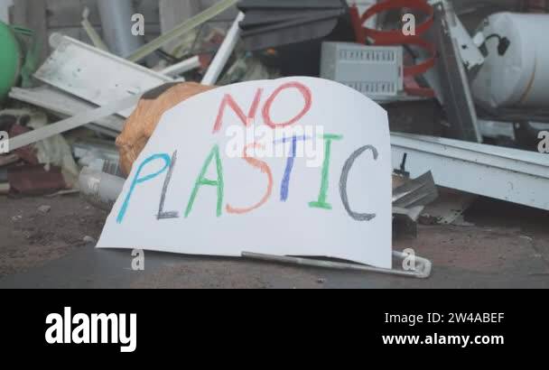 No plastic poster lying on garbage outdoors. Human impact on environment. Pollution of nature by ...