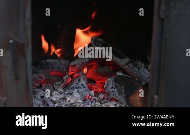 firewood burns in a fire with a red flame in a stove at a summer ...