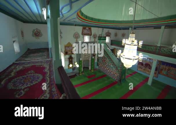 Muslim mosque teacher is reading quran in small historic wooden masjid ...