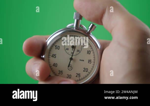 Male hand holding analogue stopwatch on green screen chroma key. Time ...