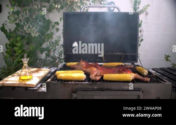 4K, Crispy roasted piglet which are being grilled on barbecue with corn ...
