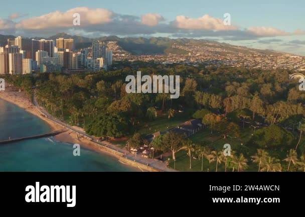 Panning aerial drone slowly flying over a colorful Honolulu Skyline ...