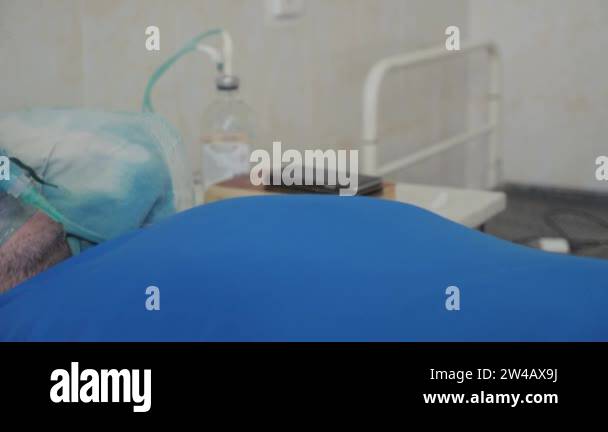 Sick man in a hospital bed. An intravenous drip is installed in the arm ...