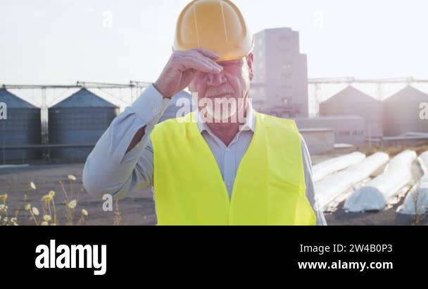 Portrait of industrial senior engineer in glasses and lifevest taking ...