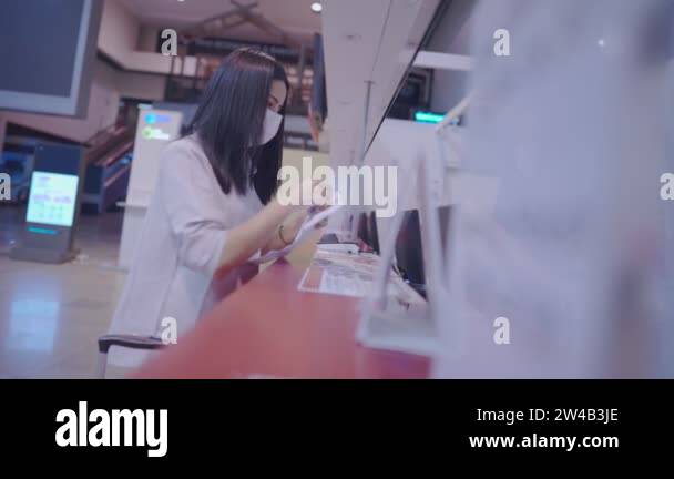 Young Asian female hand in travel documents to ticket counter staff at ...