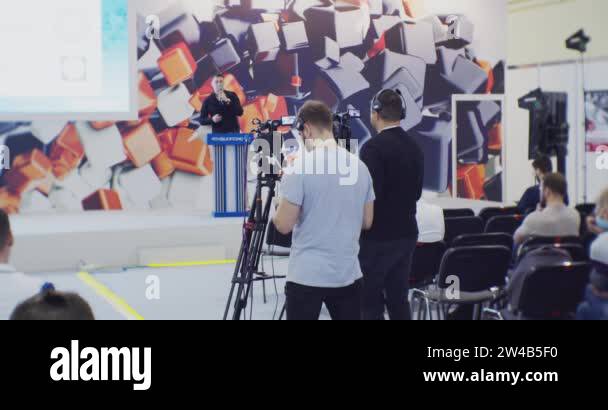 two unrecognizable cameramen shoot video with cameras on tripods in a ...