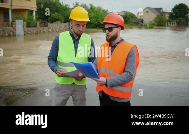 Two male engineers solve the flood problem. Natural disaster major ...