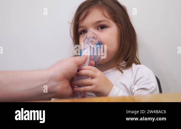 Toddler girl with oxygen nebuliser treatment at home. Inhaler therapy ...