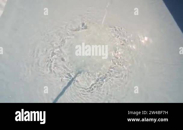 Jet of water falling on an inflatable pool, on top of a house in the ...
