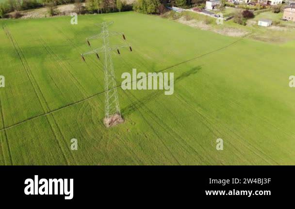 Power pylons and high voltage lines in an agricultural landscape. High ...
