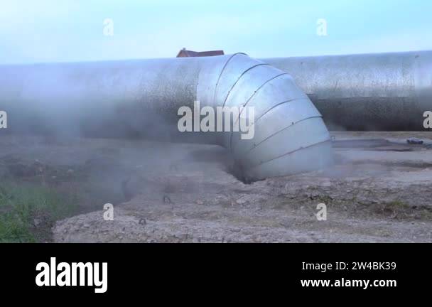 A large water pipe has burst and thick steam is coming out.A broken hot ...