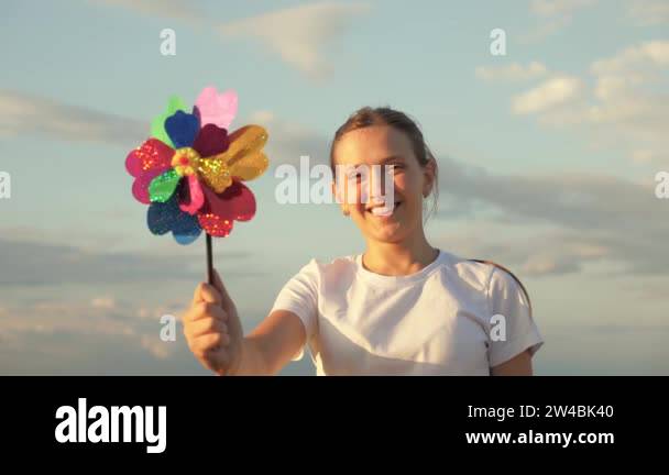 teen girl playing pinwheel park in slow motion. Happy child playing ...