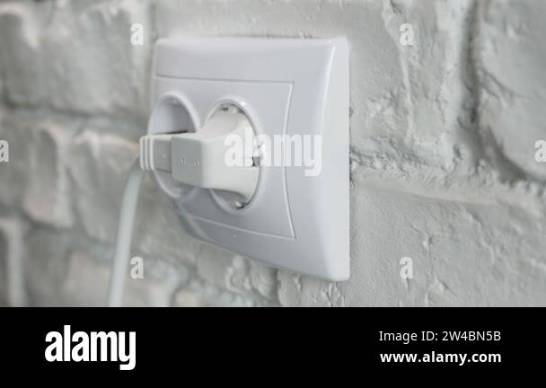 Unplugging an Electrical Power Cord from a Wall Socket in the Office ...