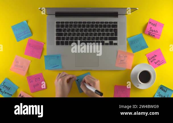 Making new remind note, writing on post it papers, laptop in office ...