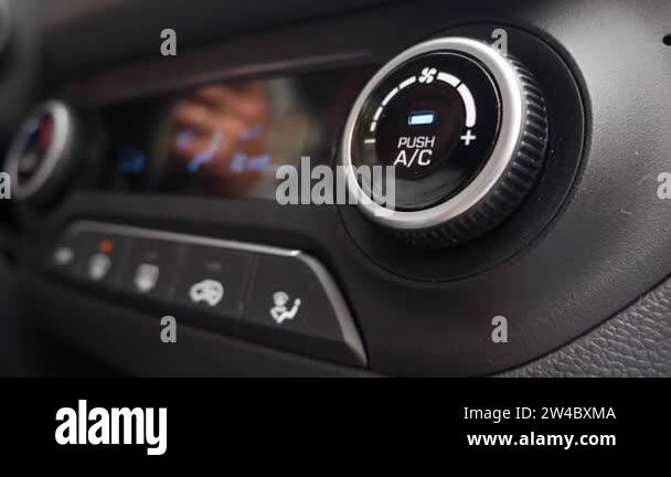 Close-up of pushing a button to turn off the air conditioner in a car ...