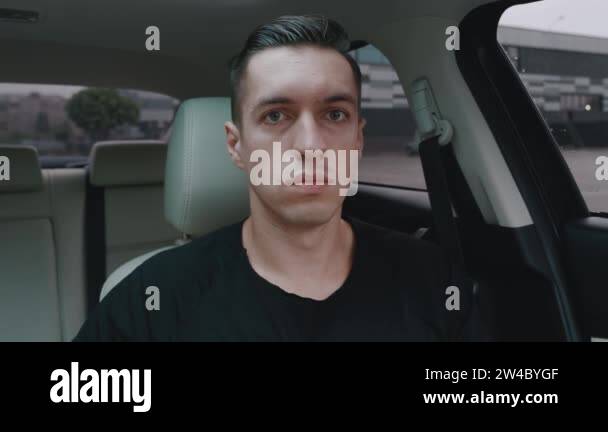 Scared man driver looks into camera with startle at face clutches his ...