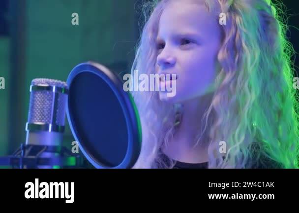 Cheerful and happy young girl on stage sings song and dances. Recording ...