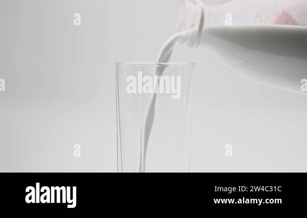 Daily dose of milk. Shot of pouring, splashing fresh milk into a ...