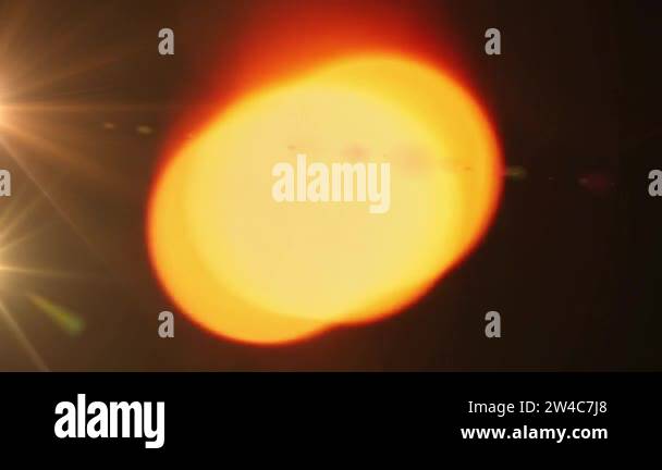 Animation of glowing blob of orange light floating with spots of bokeh ...