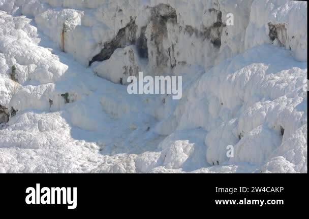 White travertine rock formed with the calcium carbonate mineral in the ...