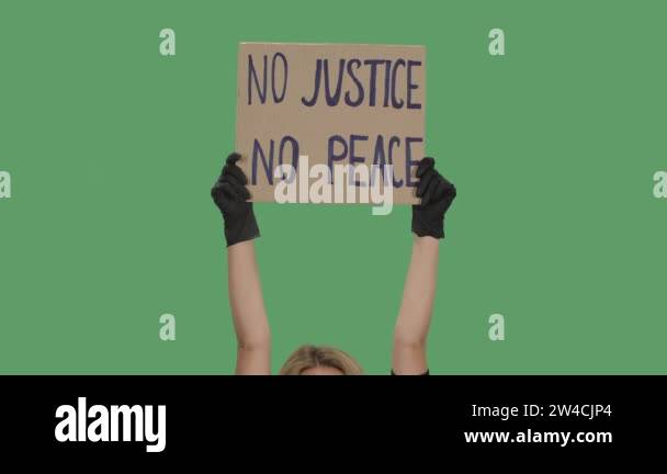 The hands of an unknown person in black gloves raise a cardboard poster ...