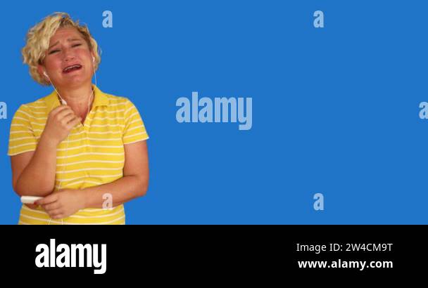 Portrait of a middle aged blonde woman with headphone listening to ...