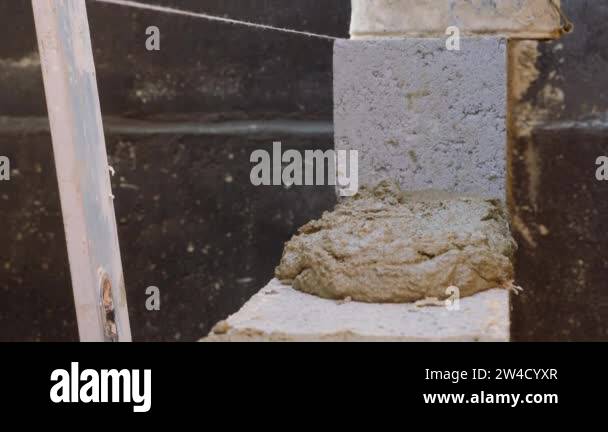 Construction work. Cinder block laying. Work of masons. Leveling the ...