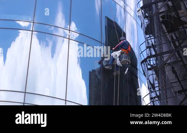 Industrial climber wash windows of skyscraper. Window washers on glass ...
