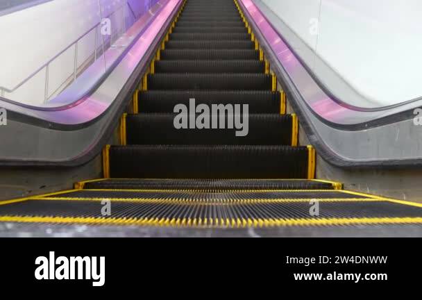 Low angle looped perspective view of modern escalator stairs. Automated ...