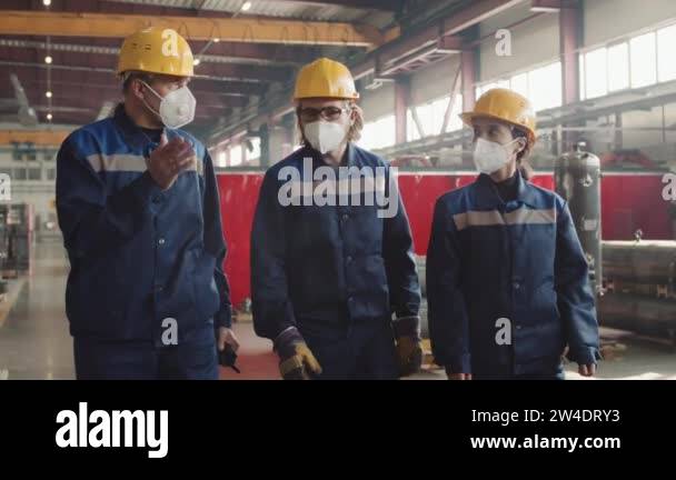 Medium slowmo of shift supervisor with male and female workers in ...