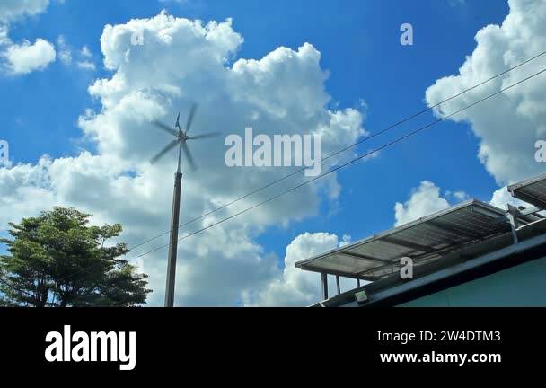 Solar panels on a roof and Wind Turbine with Blue Sky and Cloud ...