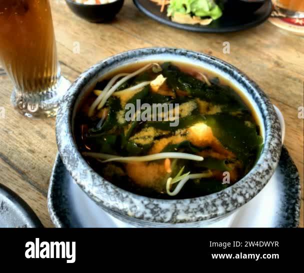 Miso soup in the big ceramic bowl. It is traditional japanese food. Main ingredients are miso ...