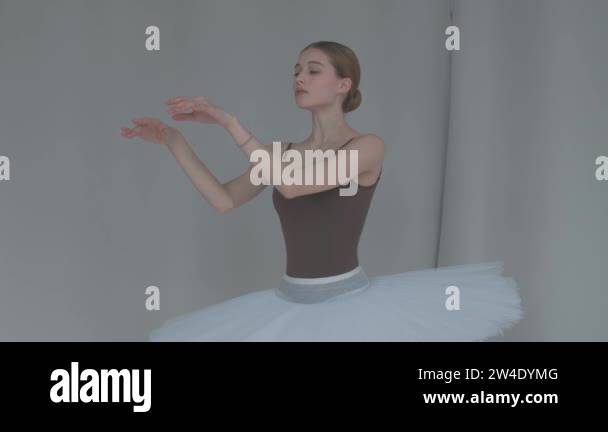 Female dancer ballet on a light coloured background performs smooth ...